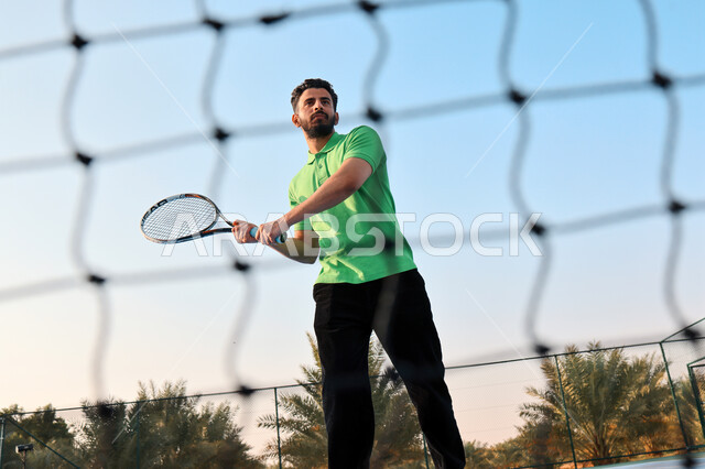 A Saudi Arabian Gulf youth plays tennis, tennis in public courts ...
