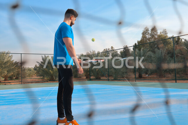 A Saudi Arabian Gulf youth plays tennis, tennis in public courts ...