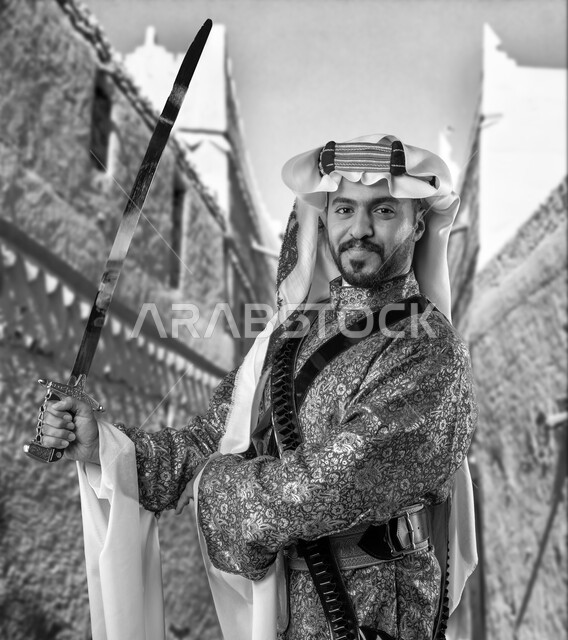 A Saudi Arab Gulf man in Saudi dress for the founding day holding a ...