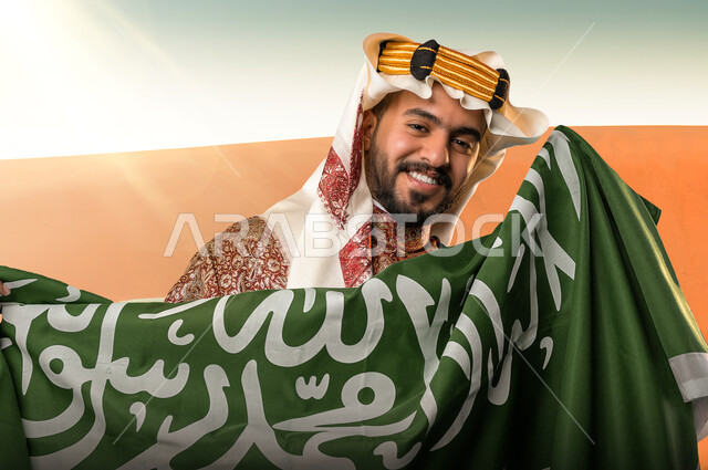 A Saudi Arabian Gulf man in traditional Saudi dress carrying the Saudi ...