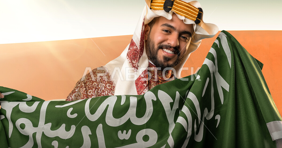 A Saudi Arabian Gulf man in traditional Saudi dress carrying the Saudi ...