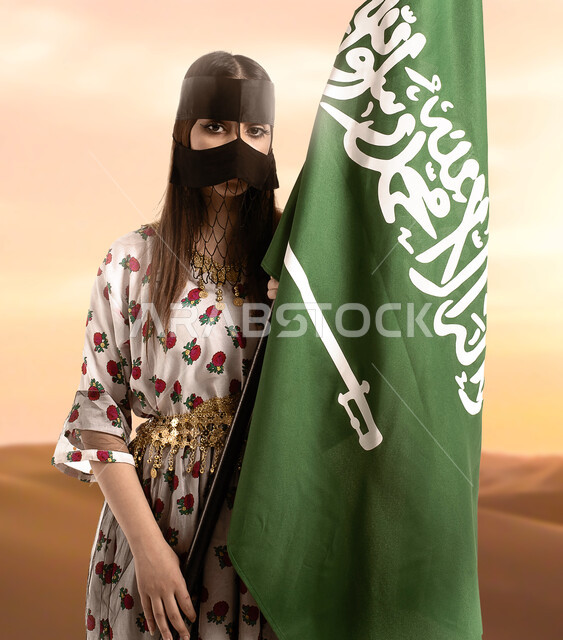 A Saudi Arab Gulf woman carrying the flag of the Kingdom of Saudi ...