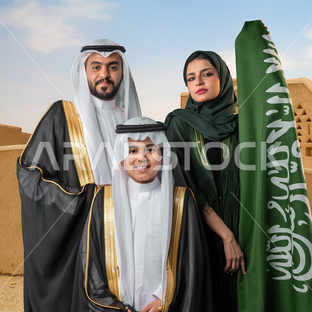 A Saudi Gulf Arab family in traditional Saudi dress, the Saudi flag ...