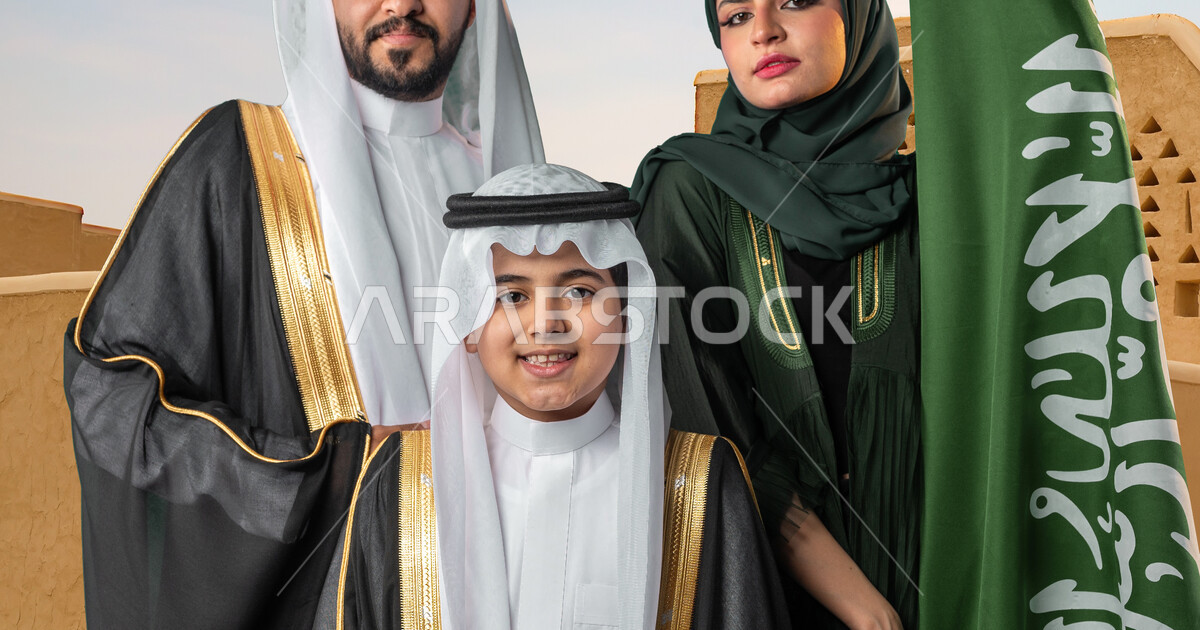 A Saudi Gulf Arab family in traditional Saudi dress, the Saudi flag ...