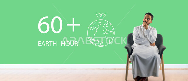 A Saudi Arabian Gulf man sits on a chair and puts his hand on his chin ...