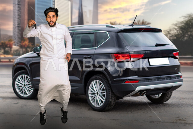A Saudi Arabian Gulf man holding a car key in his hand and jumping for ...