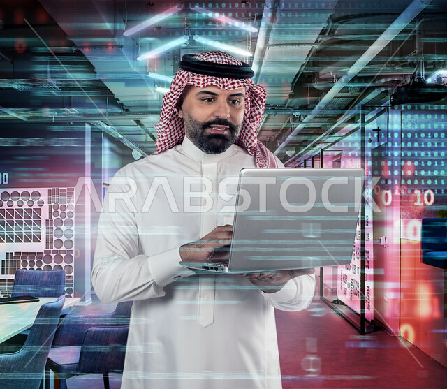 A Saudi Arabian Gulf man using a laptop to develop a computer network ...