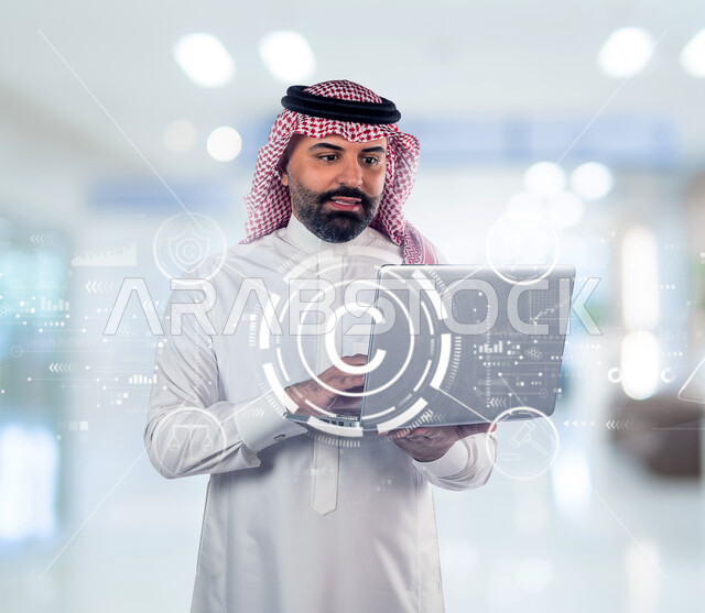 A Saudi Arabian Gulf man using a laptop to develop a computer network ...