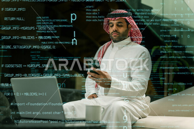 A Saudi Arabian Gulf man using a laptop to develop a computer network ...
