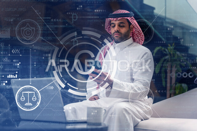 A Saudi Arabian Gulf man using a laptop to develop a computer network ...