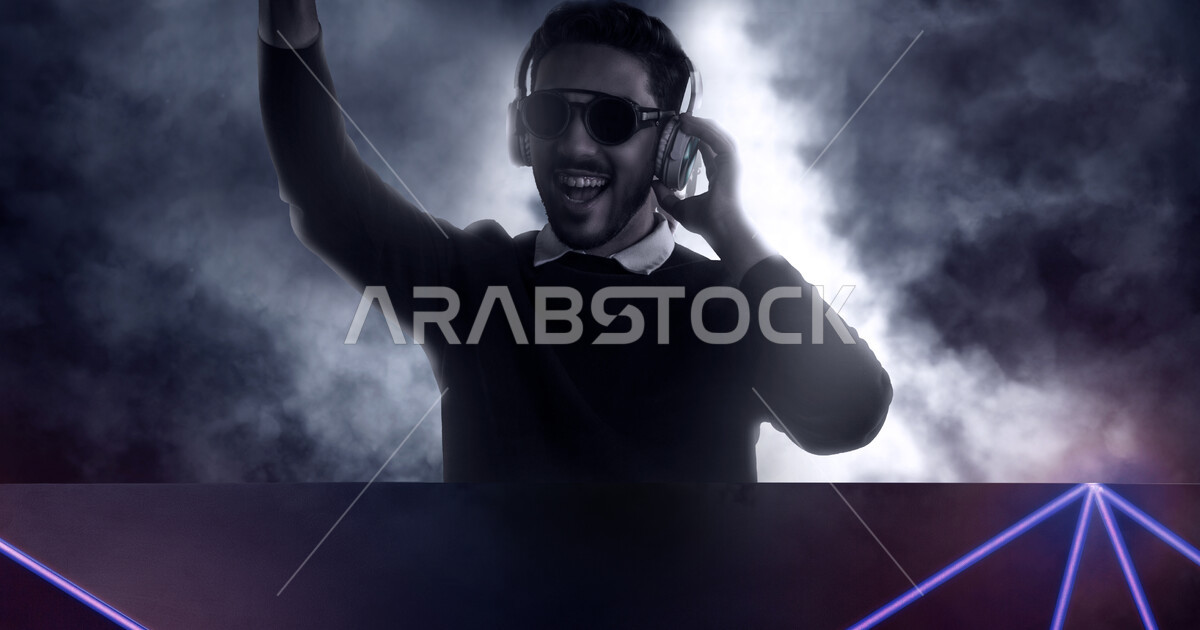 رجل عربي خليجي سعودي يضع سماعة رأس ويرتدي نظارة سوداء، ايماءات وجه و ...