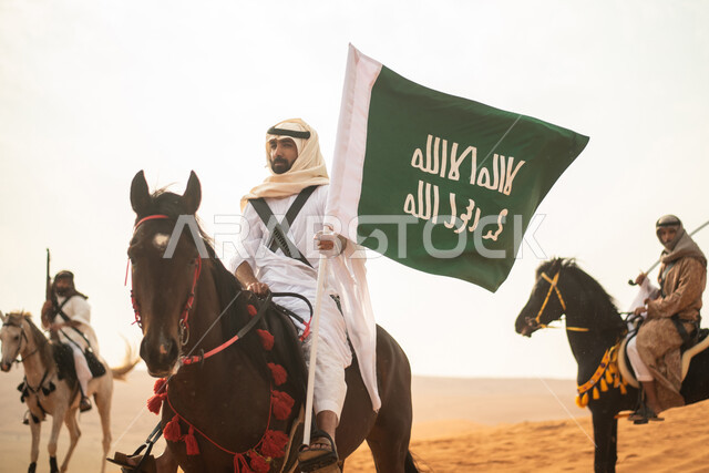 Saudi Gulf Arab knights riding horses in the Saudi desert, raising the ...