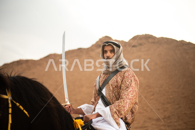 A Saudi Arab Gulf knight riding horses in the Saudi desert, the Saudi ...