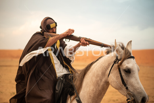 A Saudi Arab Gulf knight riding a horse in the desert of Saudi Arabia ...