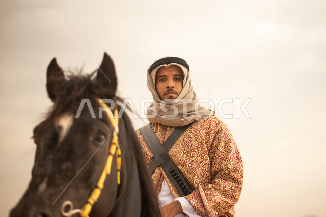 A Saudi Arabian Khaleeji knight riding an Arabian horse in the Saudi ...