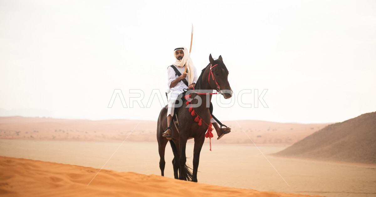 A Saudi Arabian Khaleeji knight riding horses in the Saudi desert ...