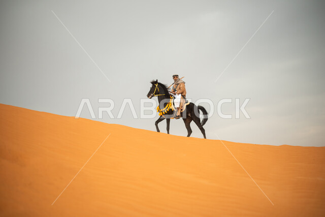 A Saudi Arabian Khaleeji knight riding horses in the Saudi desert ...