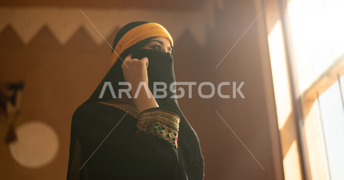 A Saudi Arab Gulf woman wearing the niqab and standing in front of the ...