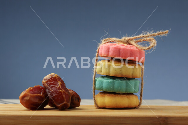 Square colored date maamoul, fragile popular sweets on a wooden board ...