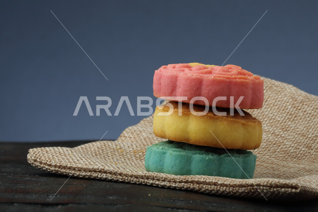 Square colored date maamoul, fragile popular sweets on a wooden board ...