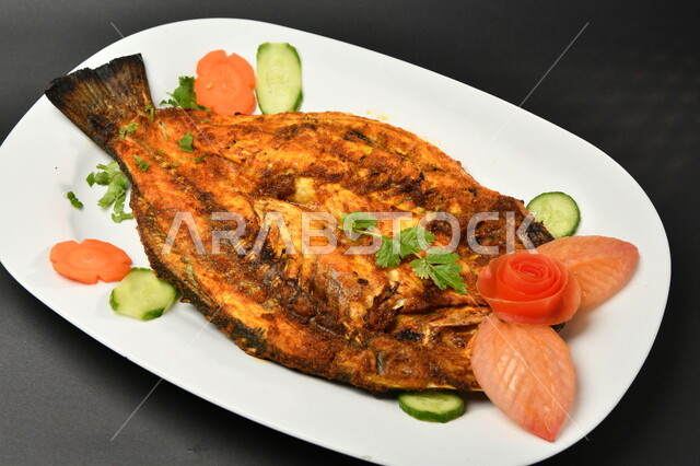 A plate of marinated fried fish on a blackened surface, seafood, arabic ...