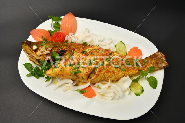 A plate of marinated fried fish on a blackened surface, seafood, arabic ...
