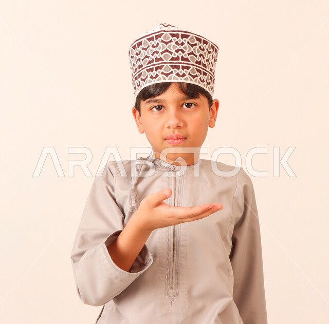 Portrait of an Omani Arab Gulf boy wearing the traditional Omani dress ...