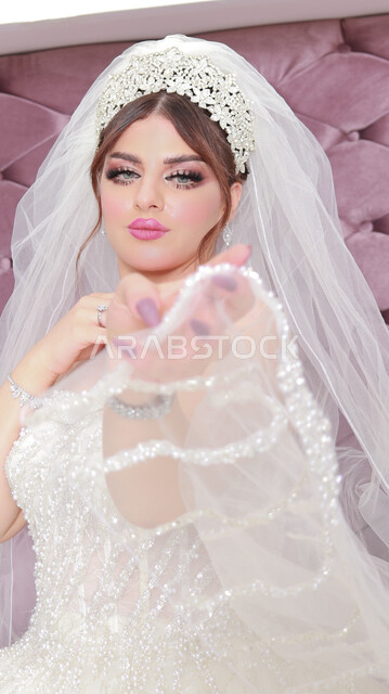 A Saudi Gulf Arab bride doing a photo session, holding a bride on her ...