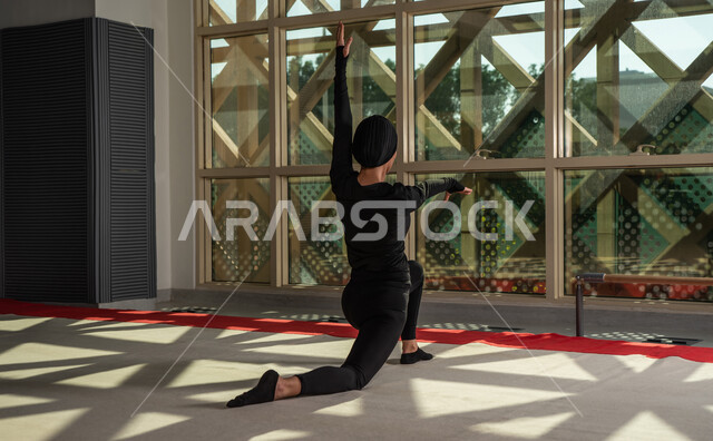 Stretching movements, a picture from the back of a veiled Saudi Gulf ...