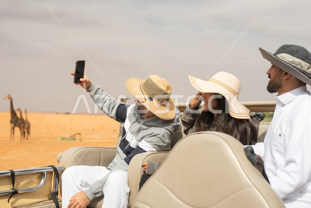 Two Saudi Arabian Gulf men and women on a tourist tour, using a mobile ...