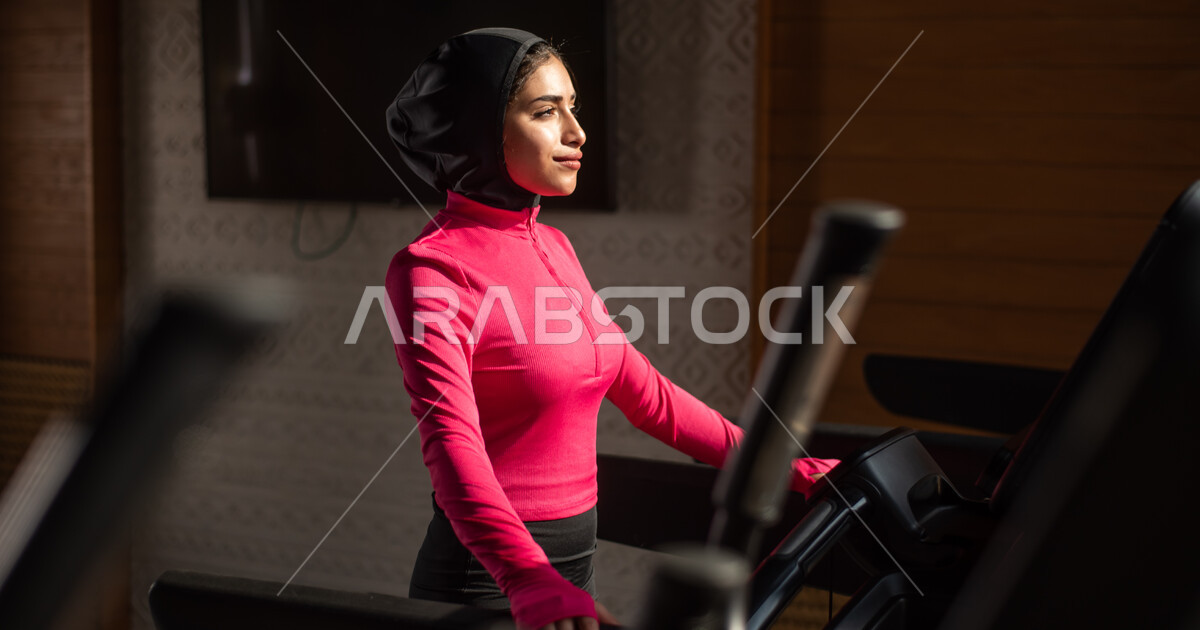 A veiled Saudi Gulf Arab woman wears sportswear and exercises, using ...