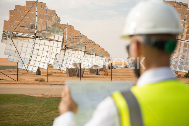A Saudi Arabian Gulf energy engineer holding a map in his hand ...