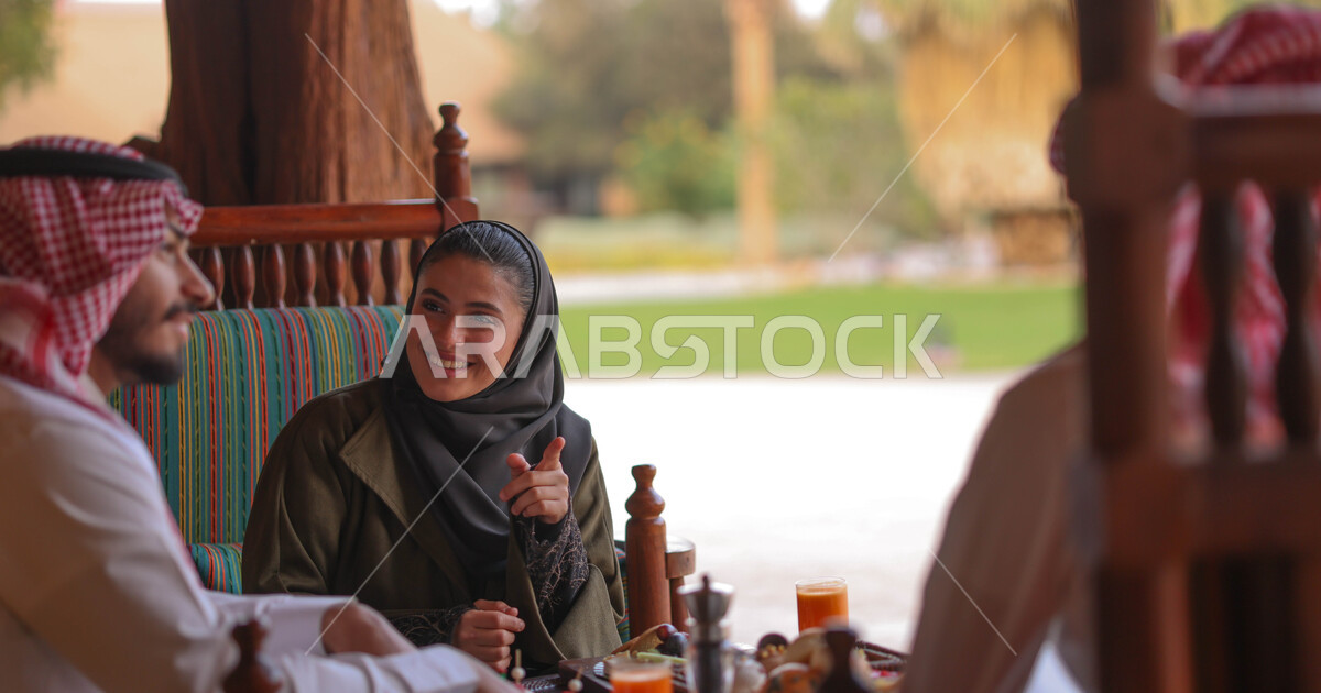 Two Saudi Gulf Arab men and women enjoying an exchange of conversation ...