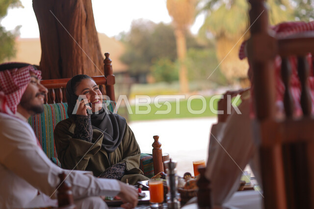 Two Saudi Gulf Arab men and women enjoying an exchange of conversation ...