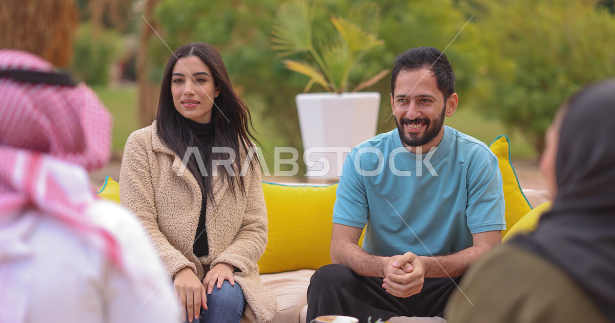 Saudi Gulf Arab friends enjoying exchanging conversations in one of the ...