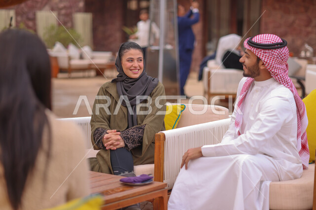 A Saudi Gulf Arab man and two women enjoying an exchange of ...
