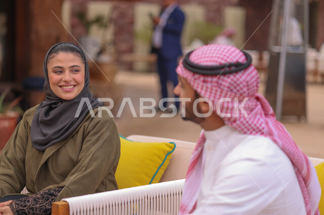 A Saudi Gulf Arab man and woman enjoying an exchange of conversation in ...