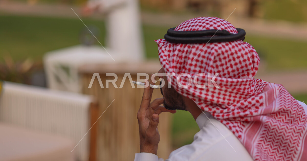 Close-up of a Saudi Arabian Gulf man smoking cigarettes, sitting ...