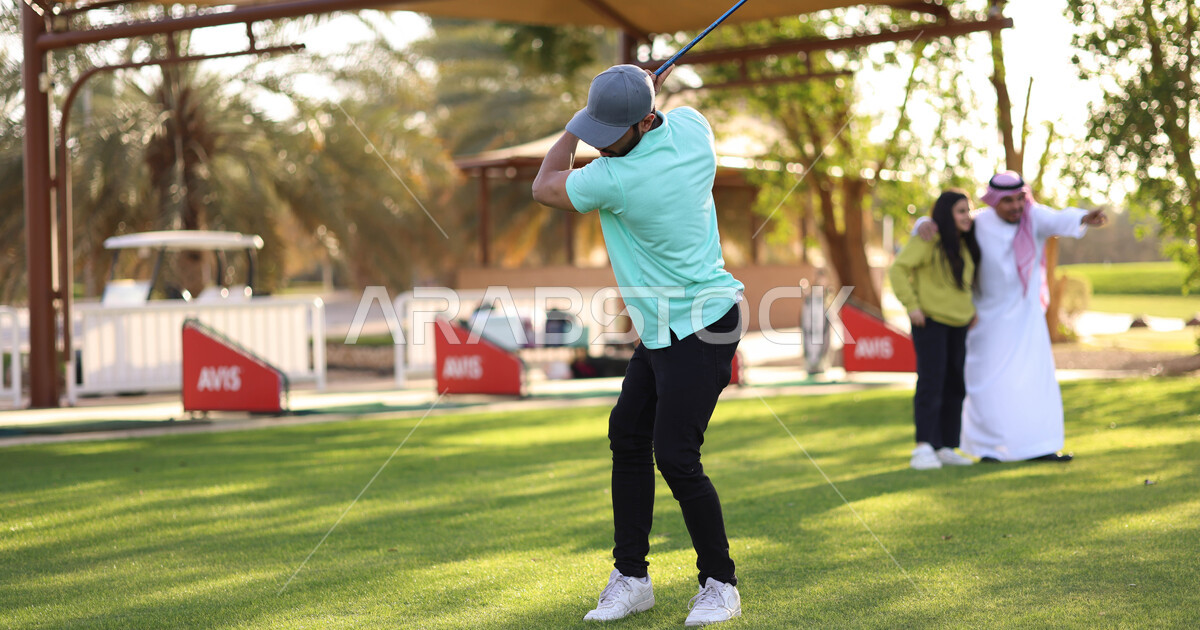 A Saudi Arab Gulf man wearing a sports uniform, playing golf on large ...
