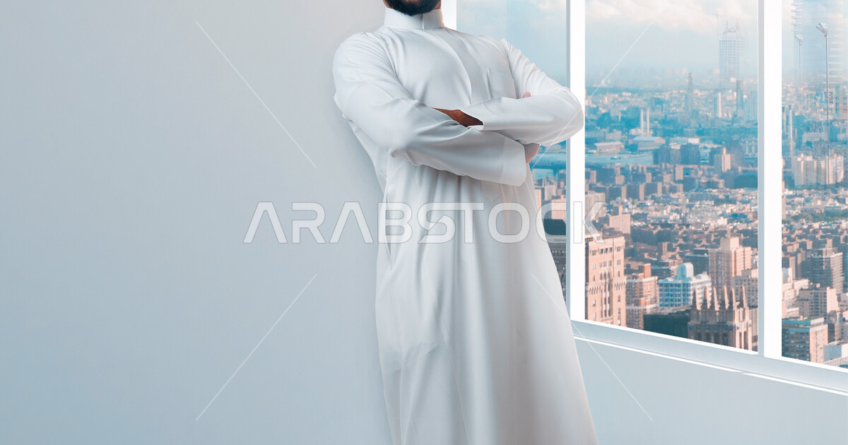 Portrait of a Saudi Arabian Gulf man in traditional dress, standing at ...