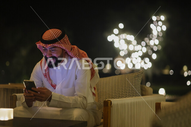 A Saudi Arabian Gulf man using a mobile phone, surfing the Internet ...