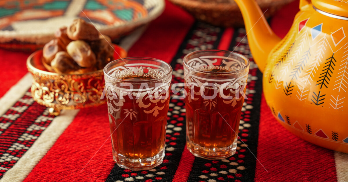 A yellow teapot with tea cups, hot drinks, serving tea, date plate ...