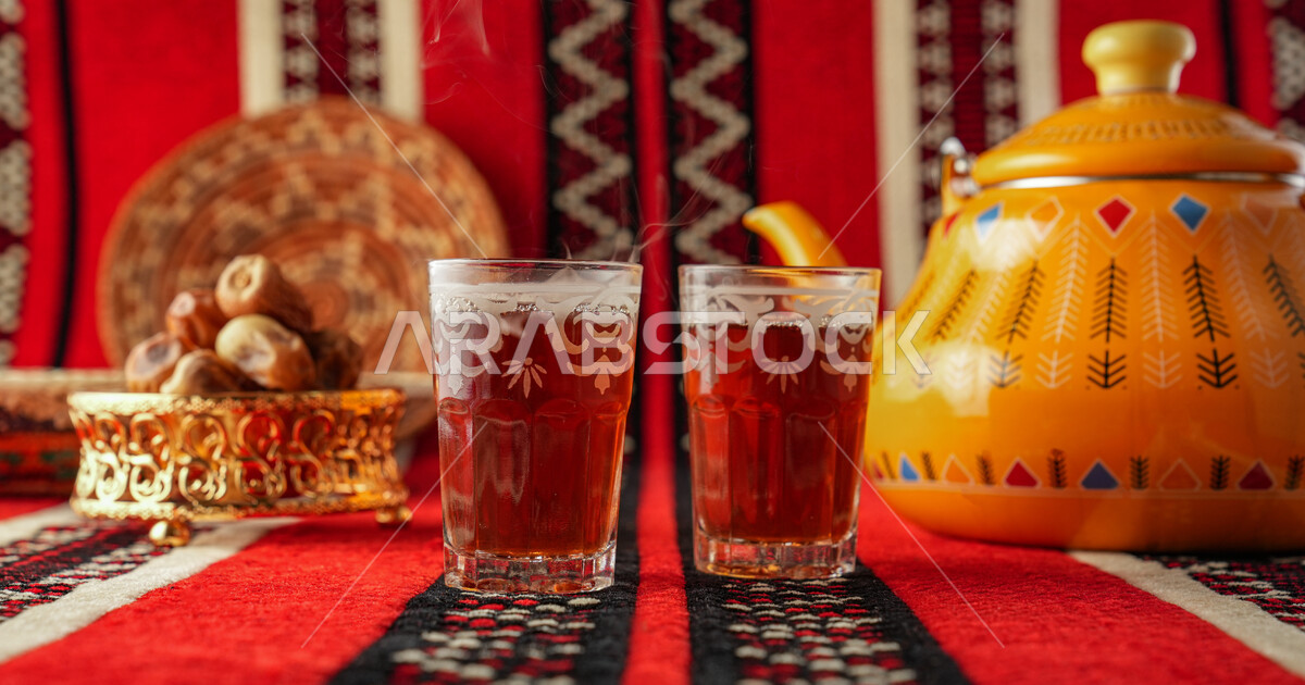A yellow teapot with tea cups, hot drinks, serving tea, date plate ...