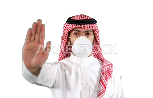 Portrait of a Saudi Arabian Gulf youth wearing a mask, raising his hand ...