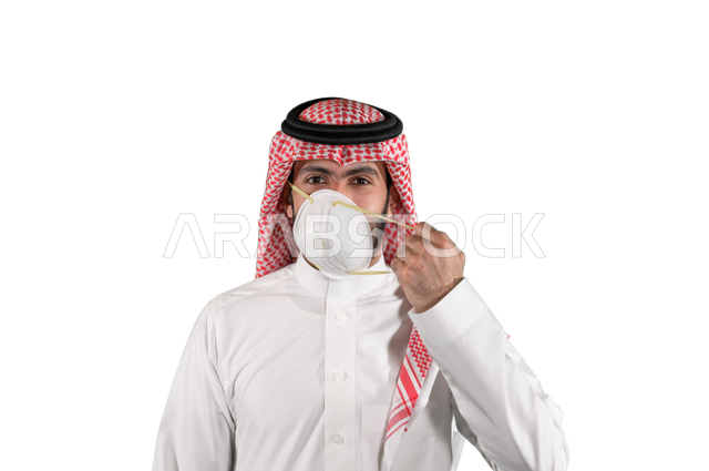 Portrait of a Saudi Arabian Gulf youth removing the protective mask ...