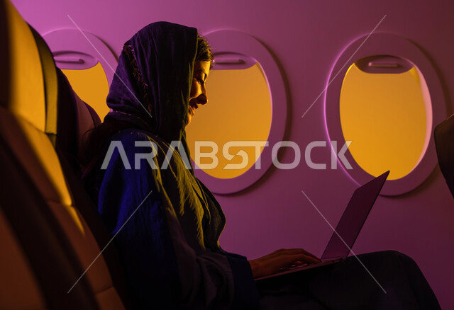 A veiled Saudi Arabian Gulf woman wearing the Gulf abaya, sitting in ...