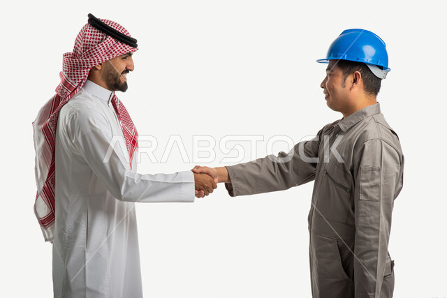 Portrait of a Saudi Arabian Gulf man in traditional Saudi dress shaking ...