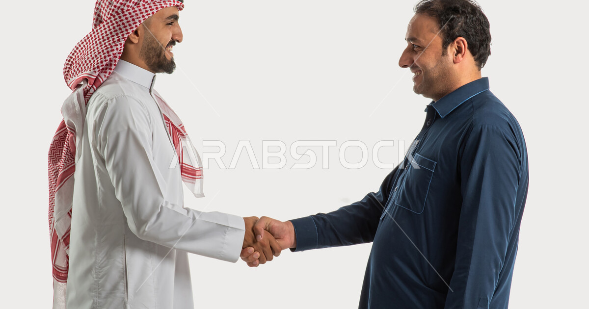 Portrait of a Saudi Arab Gulf man in traditional Saudi dress shaking ...