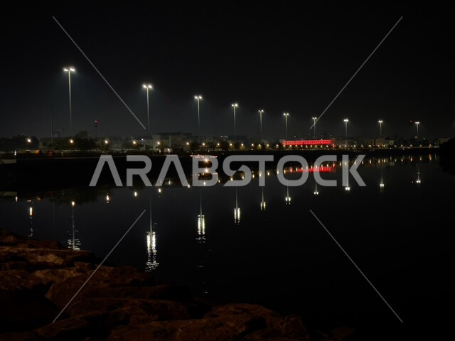Reflection of street lights on sea water at night, sea shore, lampposts ...