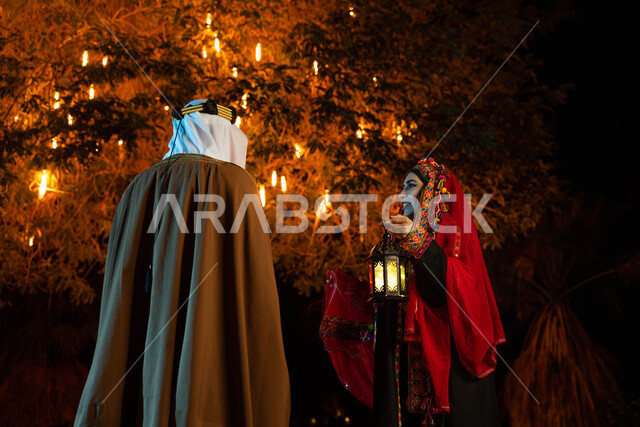 A Saudi Arabian Gulf couple dressed in a Saudi folk costume, welcoming ...
